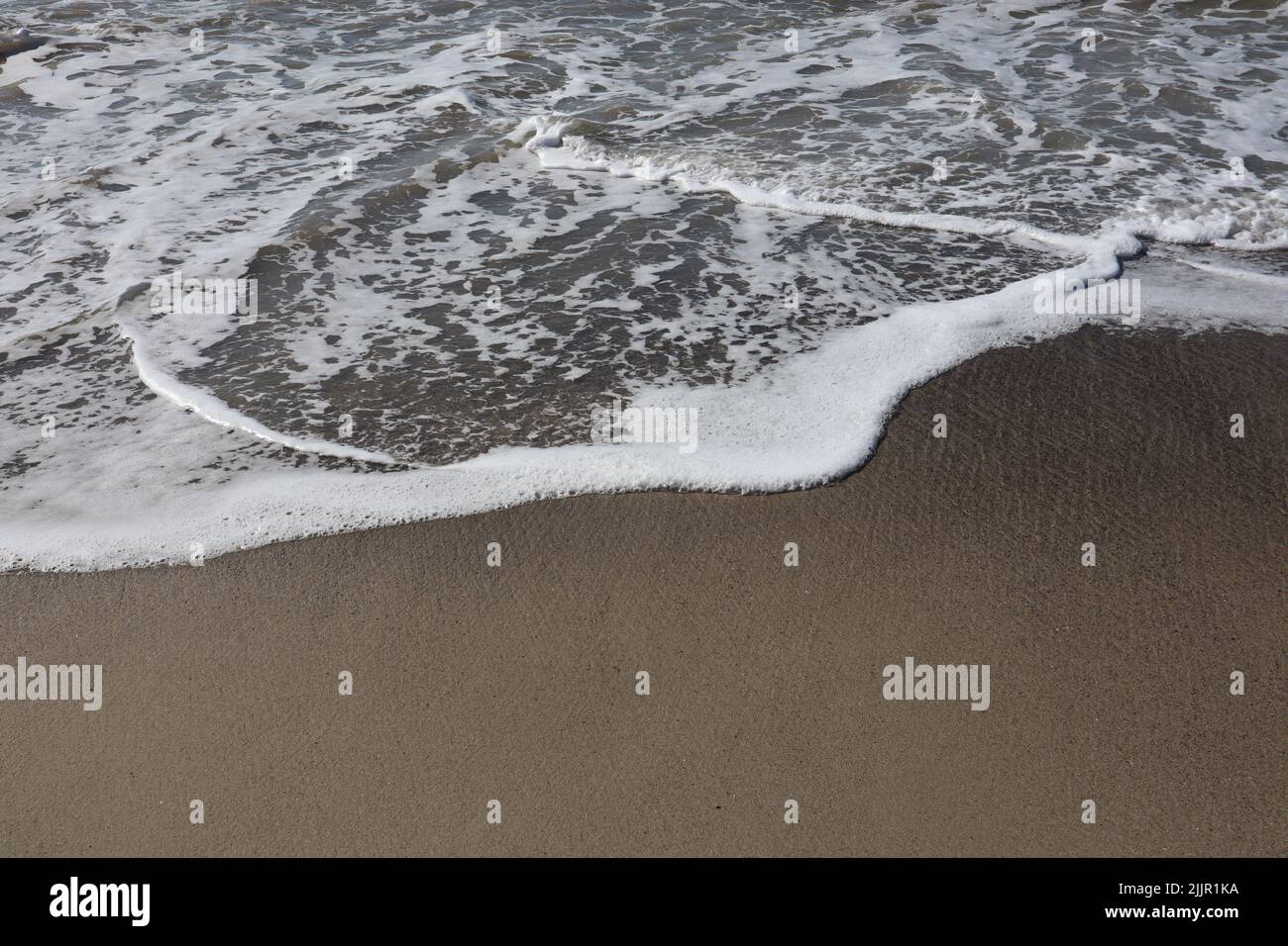 A close up of Pacific Ocean wave splashing on the beach Stock Photo - Alamy