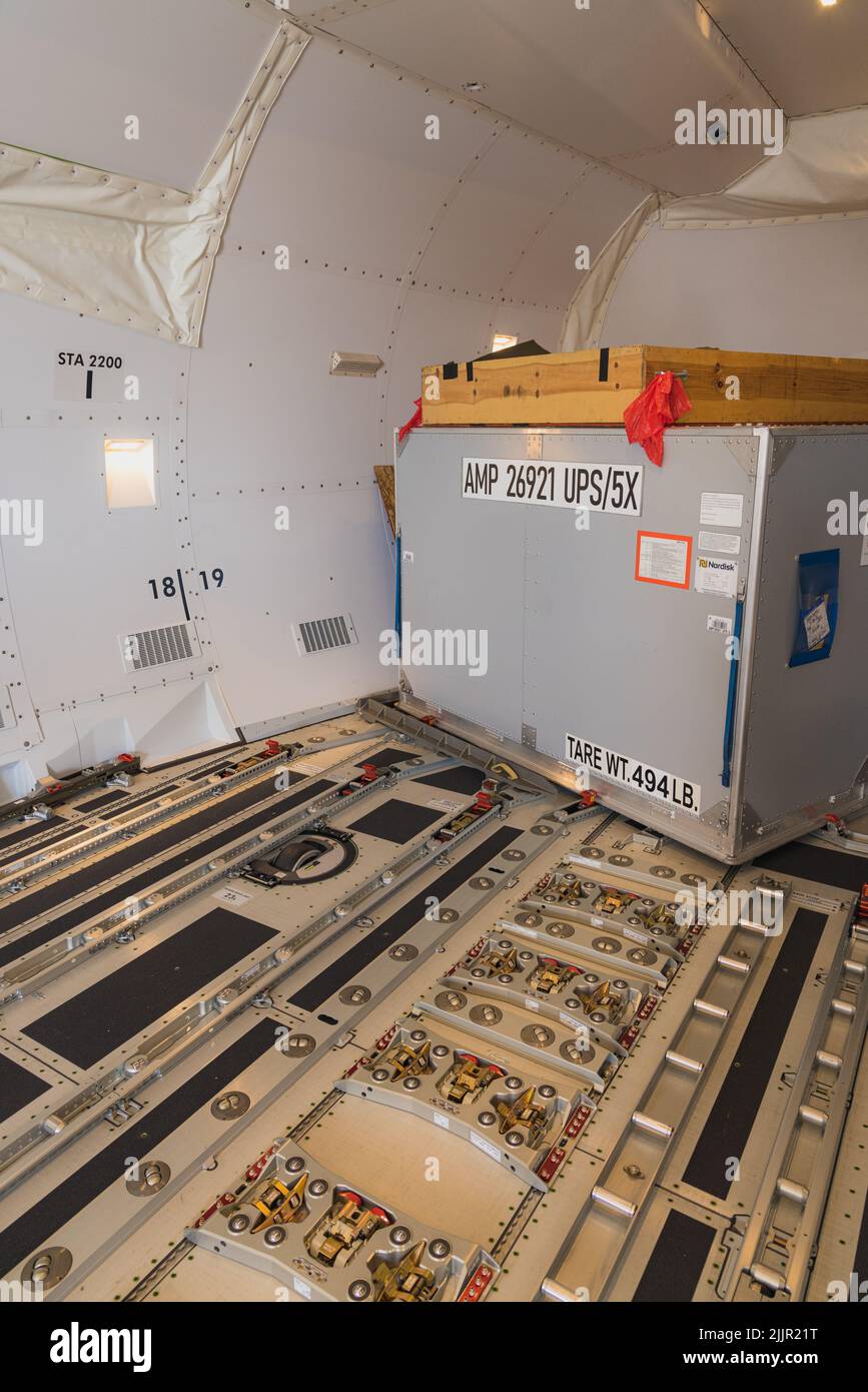 A vertical shot of cargo box on rails inside a 747-8F freight aircraft ...