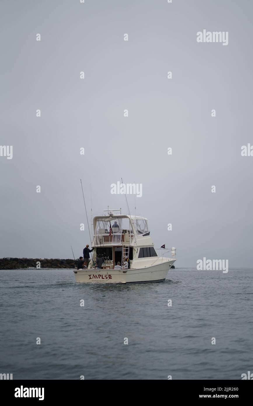 A vertical shot of a fishing boat in the sea on a gloomy day Stock ...