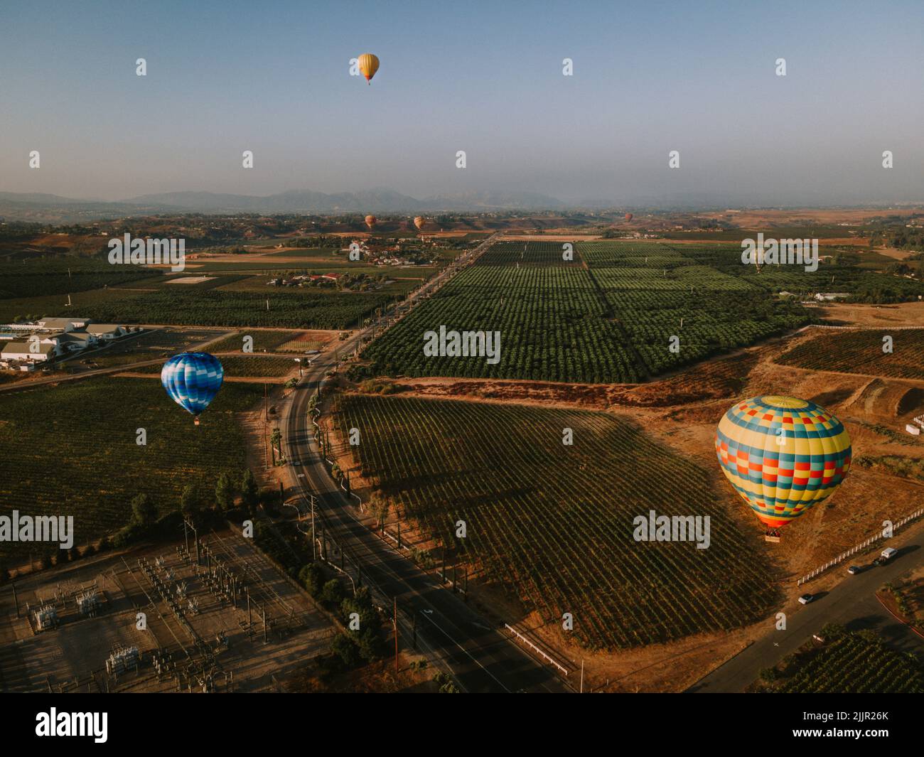 An aerial view of air balloons above the green fields Stock Photo - Alamy