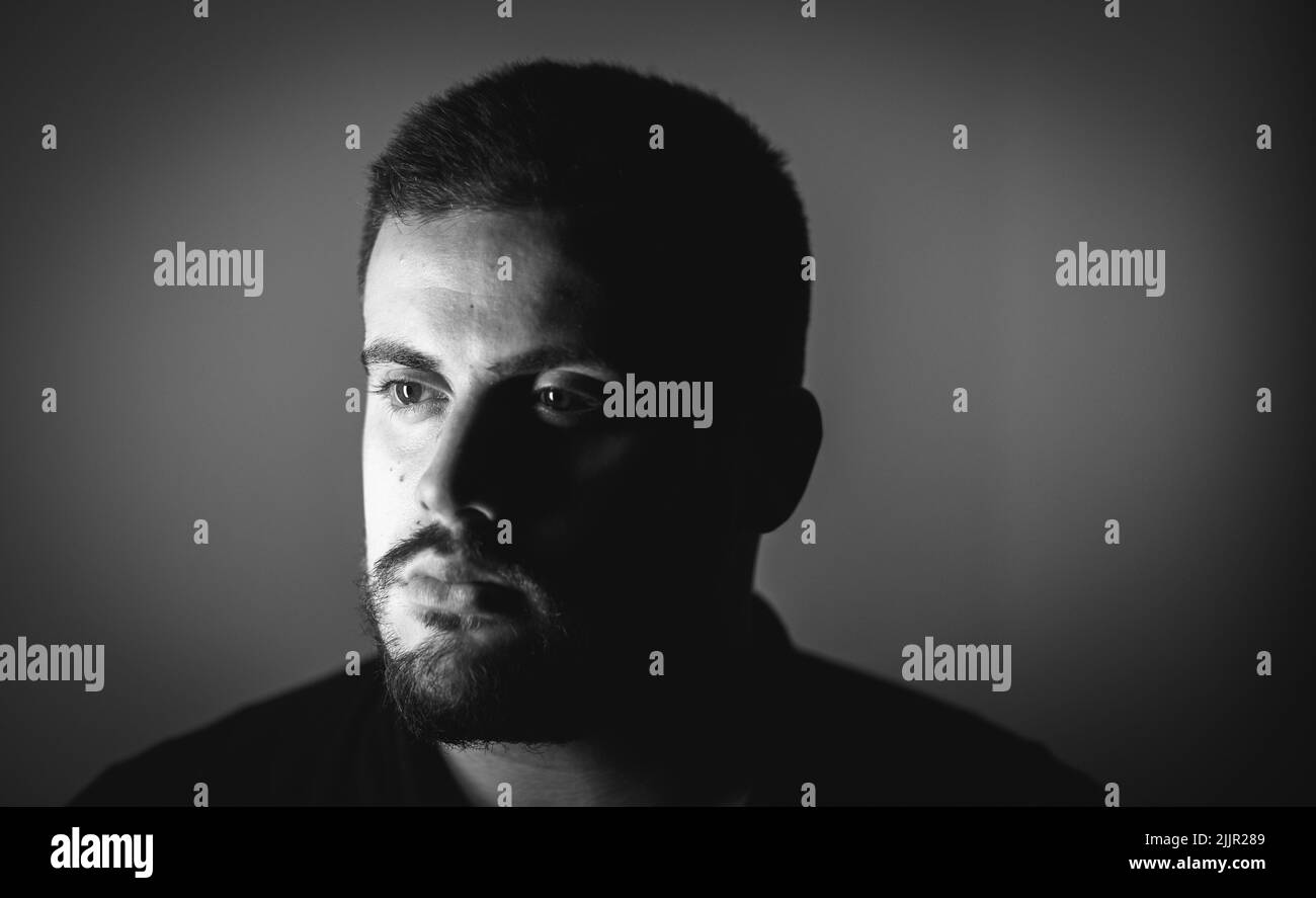 A grayscale portrait of a young Caucasian male with a serious face ...