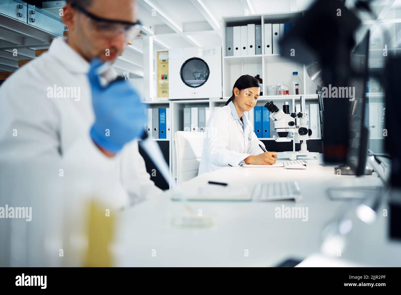 From the lab to the pharmacy. a young scientist writing notes while ...