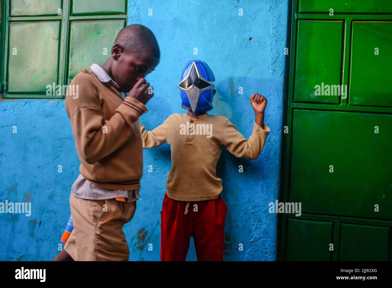 A kid poses for a photo while wearing an alien mask in Kibera Slum ...