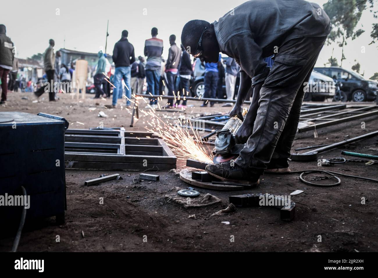 A welder works by the streets in Kibera Slum, Nairobi. Life inside ...