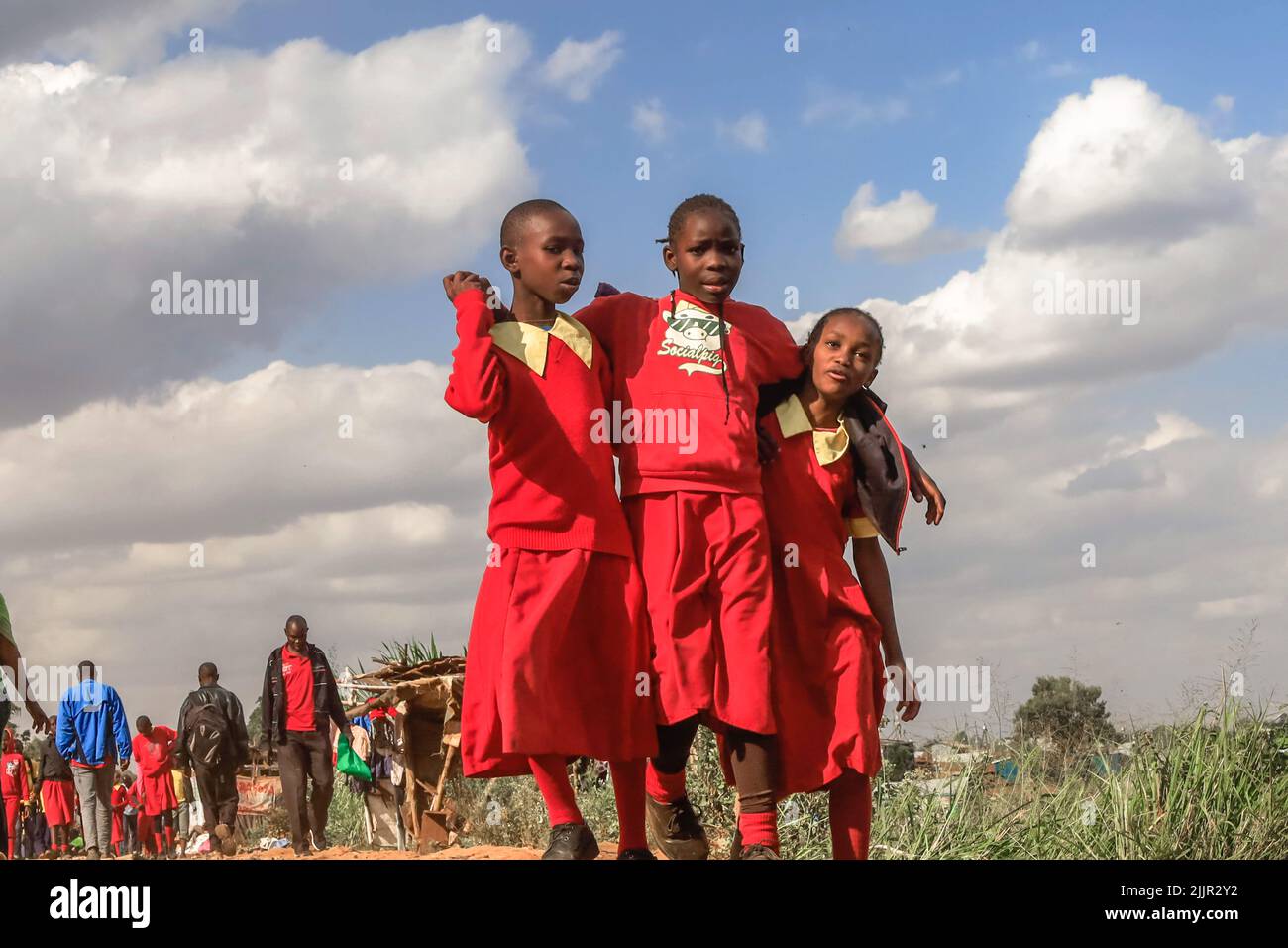 Pupils walking home from school through a train line running through ...