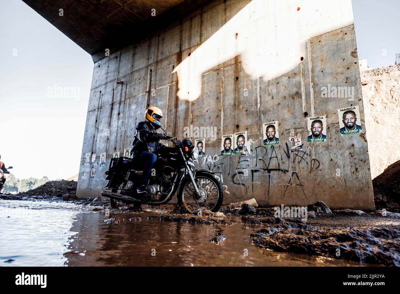 A motorcyclist rides past an unfinished construction of Kibra -Southern ...