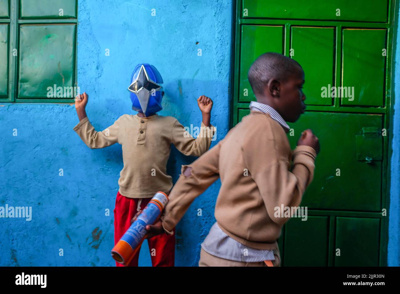 A kid poses for a photo while wearing an alien mask in Kibera Slum ...