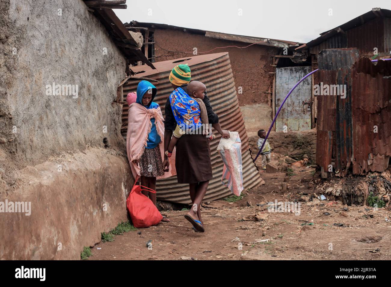 Women walk back home after disposing trash at a river running through ...