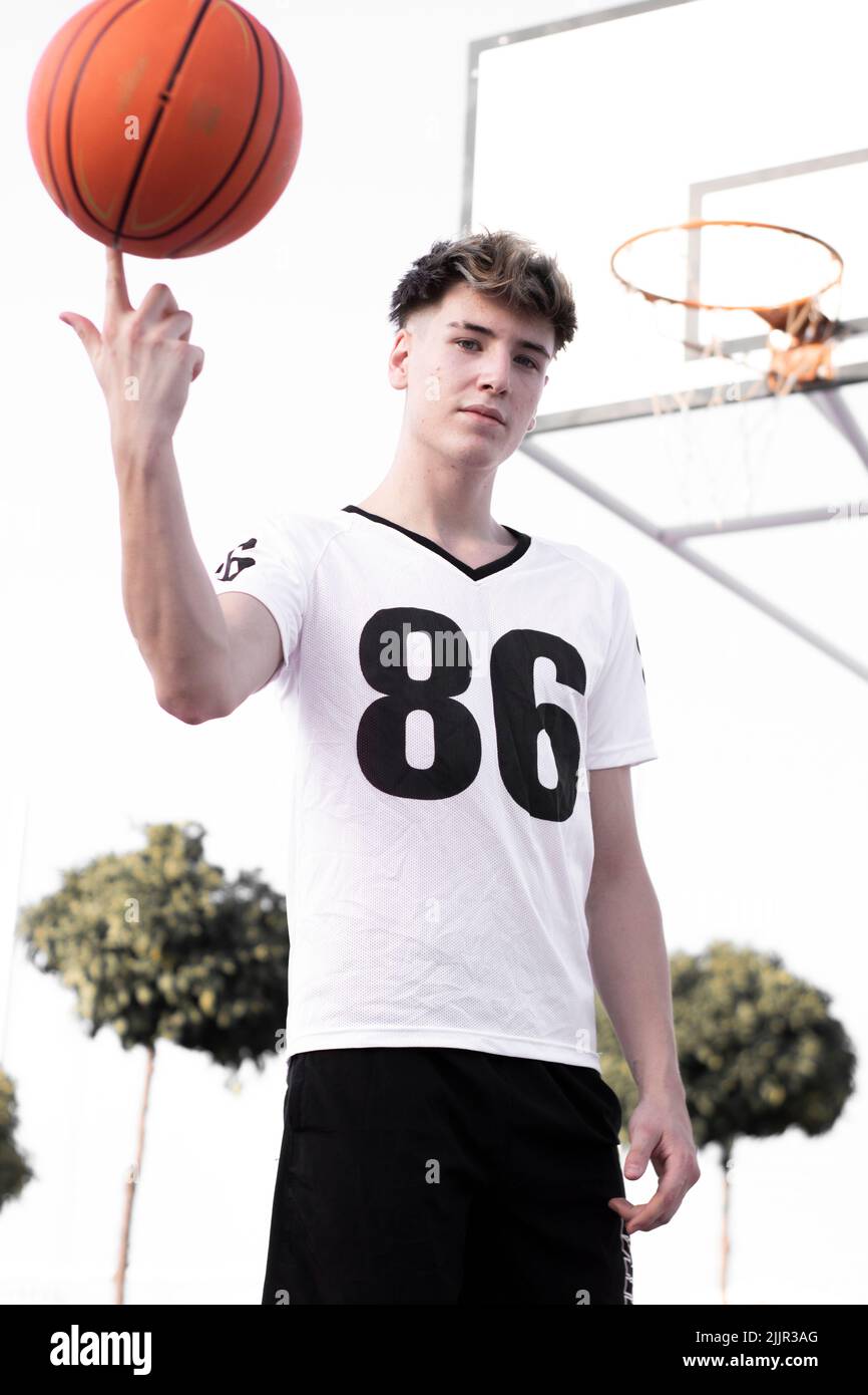 A pretty caucasian boy playing basketball on a playground Stock Photo ...