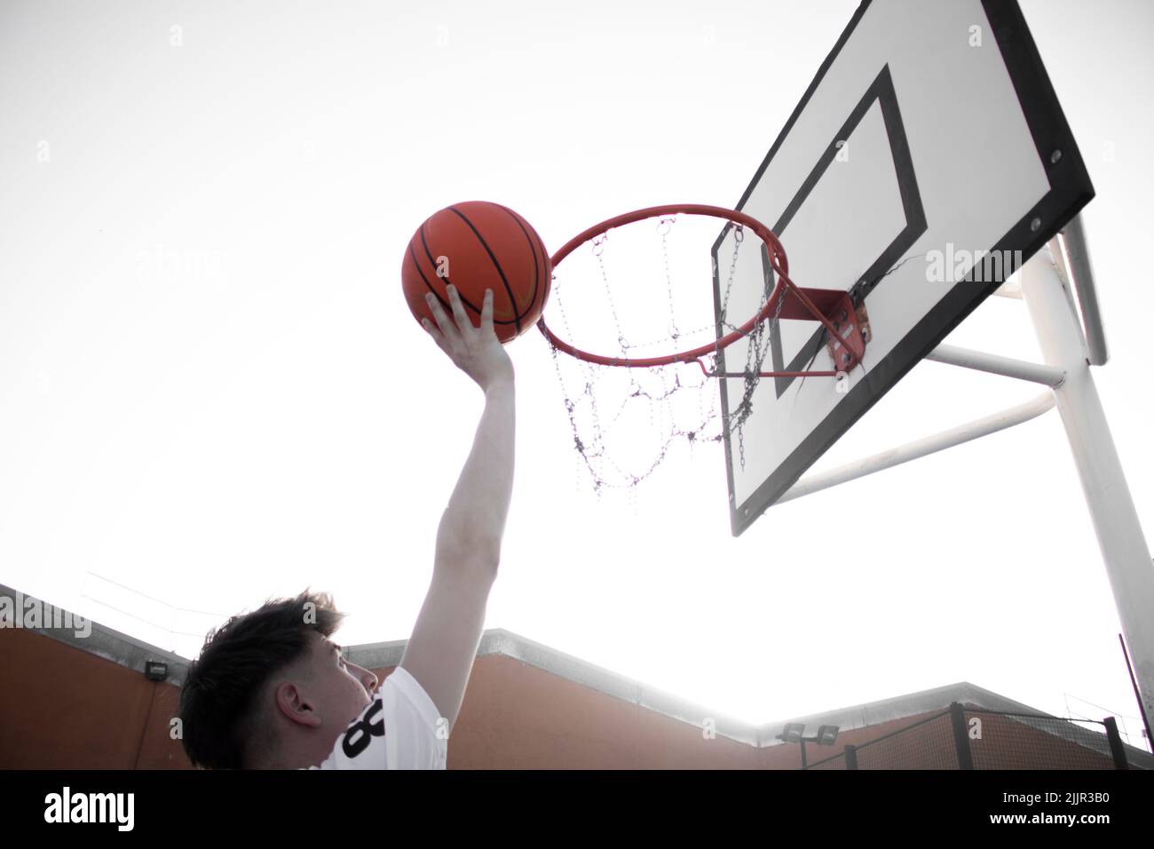 A pretty caucasian boy playing basketball on a playground Stock Photo ...