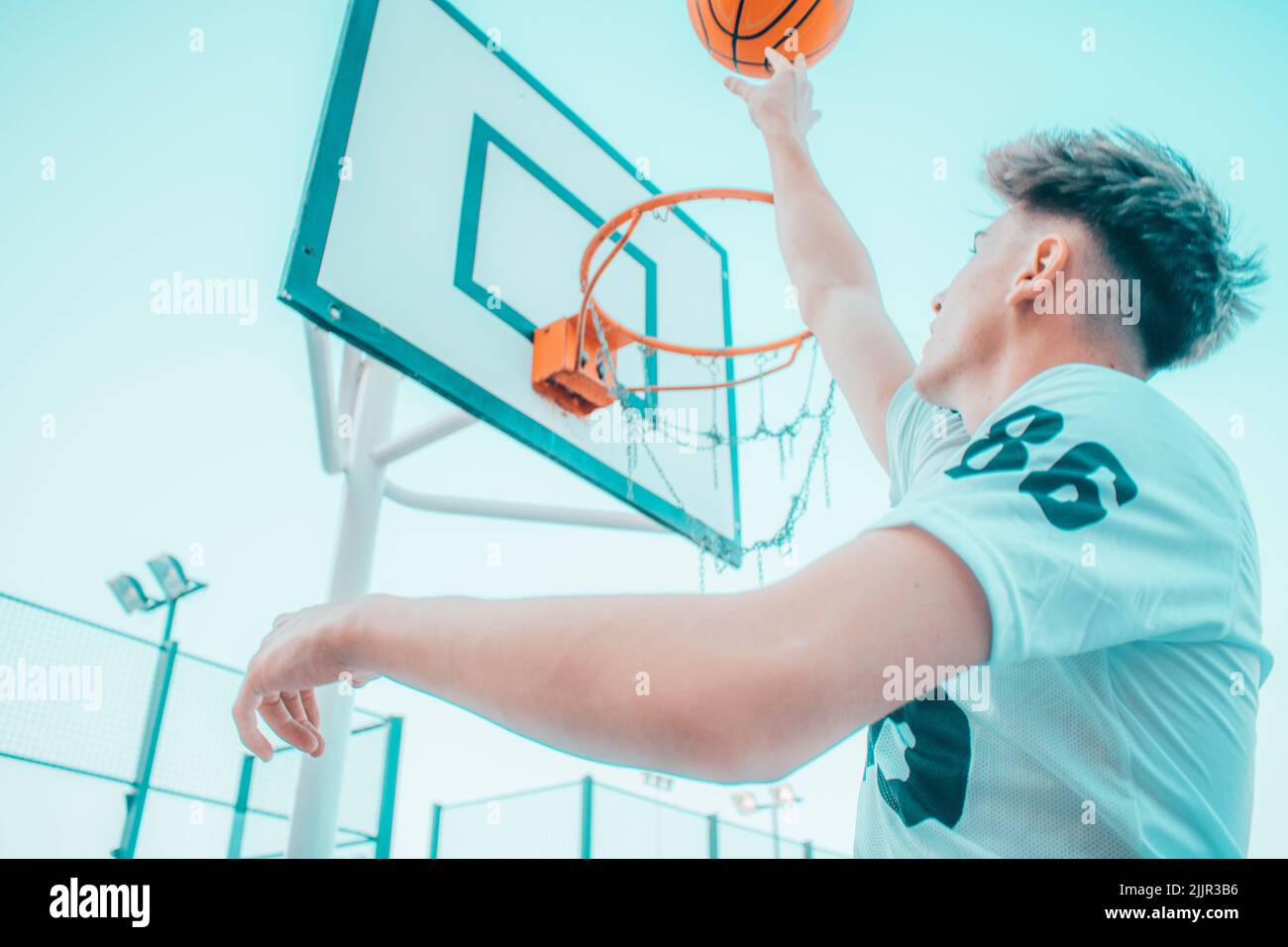 A pretty caucasian boy playing basketball on a playground Stock Photo ...