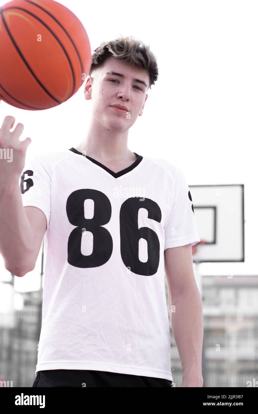 A pretty caucasian boy playing basketball on a playground Stock Photo ...