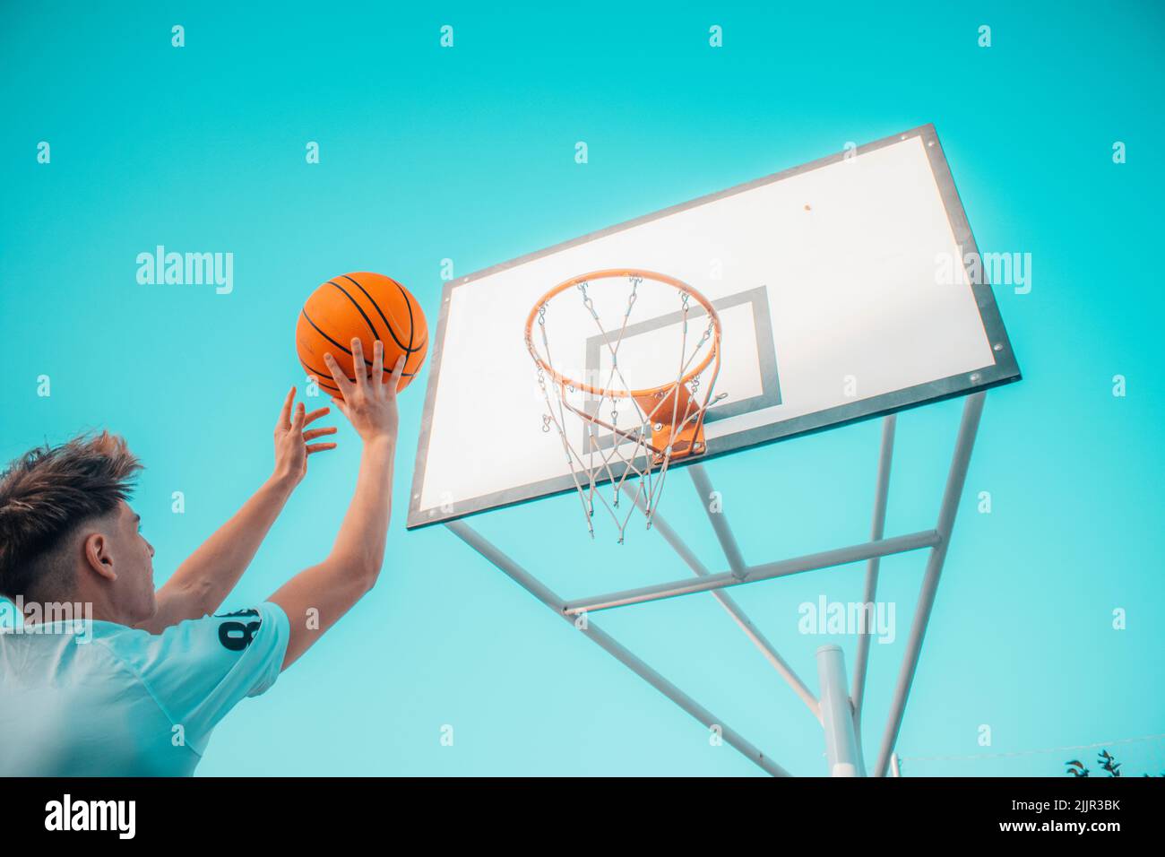 A pretty caucasian boy playing basketball on a playground Stock Photo ...