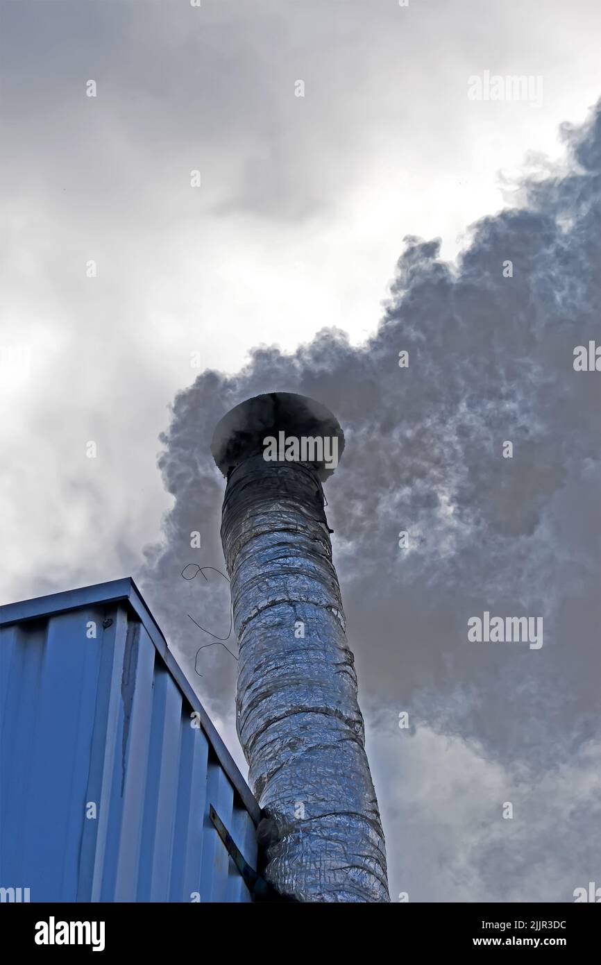 black smog from high industrial pipe with silver insolation on blue sky ...