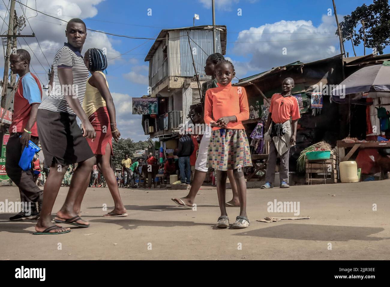 Residents walk past the busy streets in Kibera Slum, Nairobi. Life ...