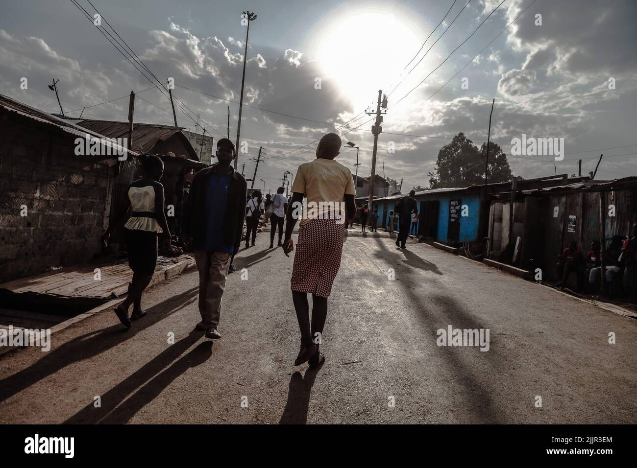 Locals walk past the normally busy neighborhoods in Kibera Slum ...