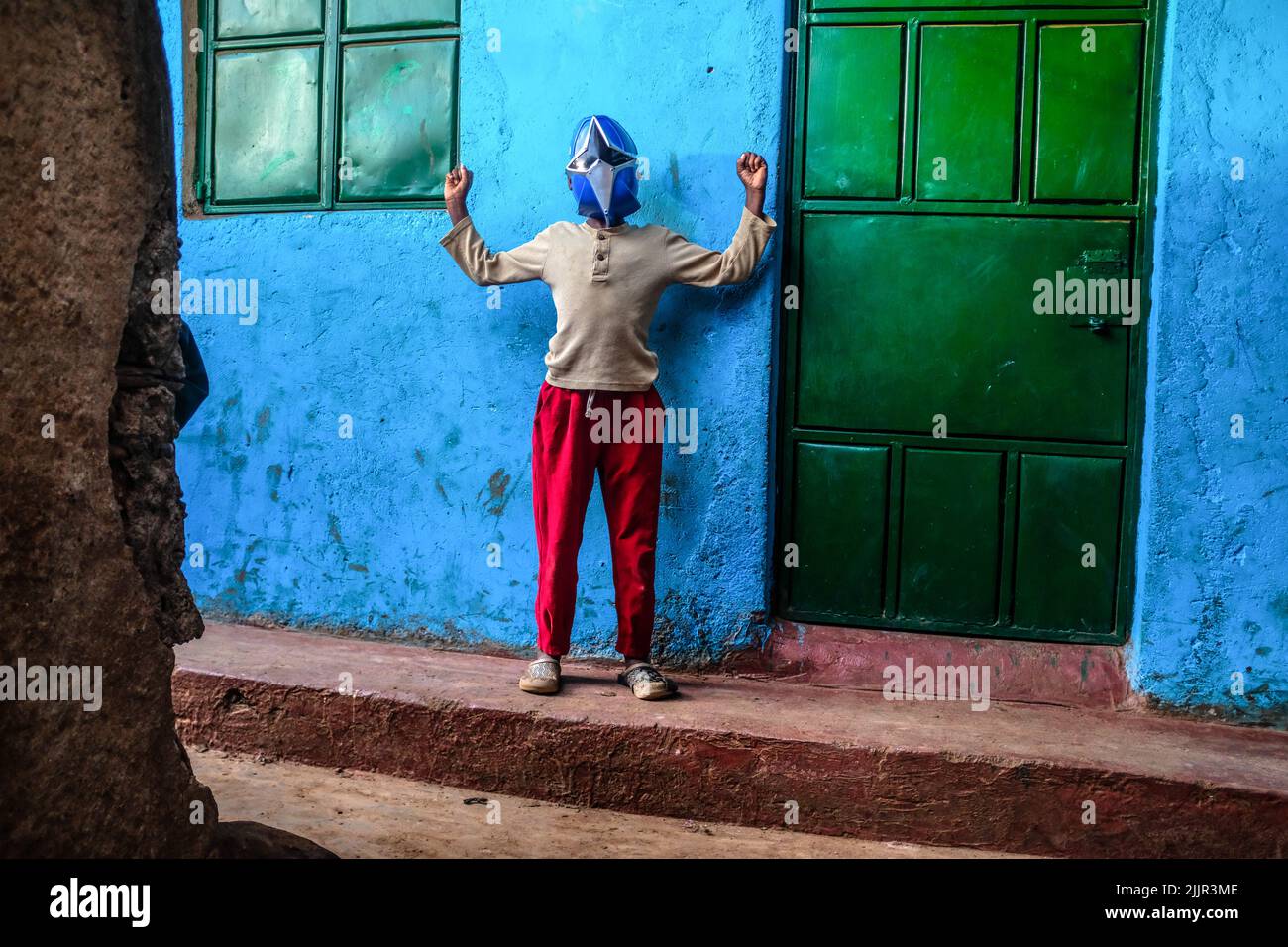 A kid poses for a photo while wearing an alien mask in Kibera Slum ...