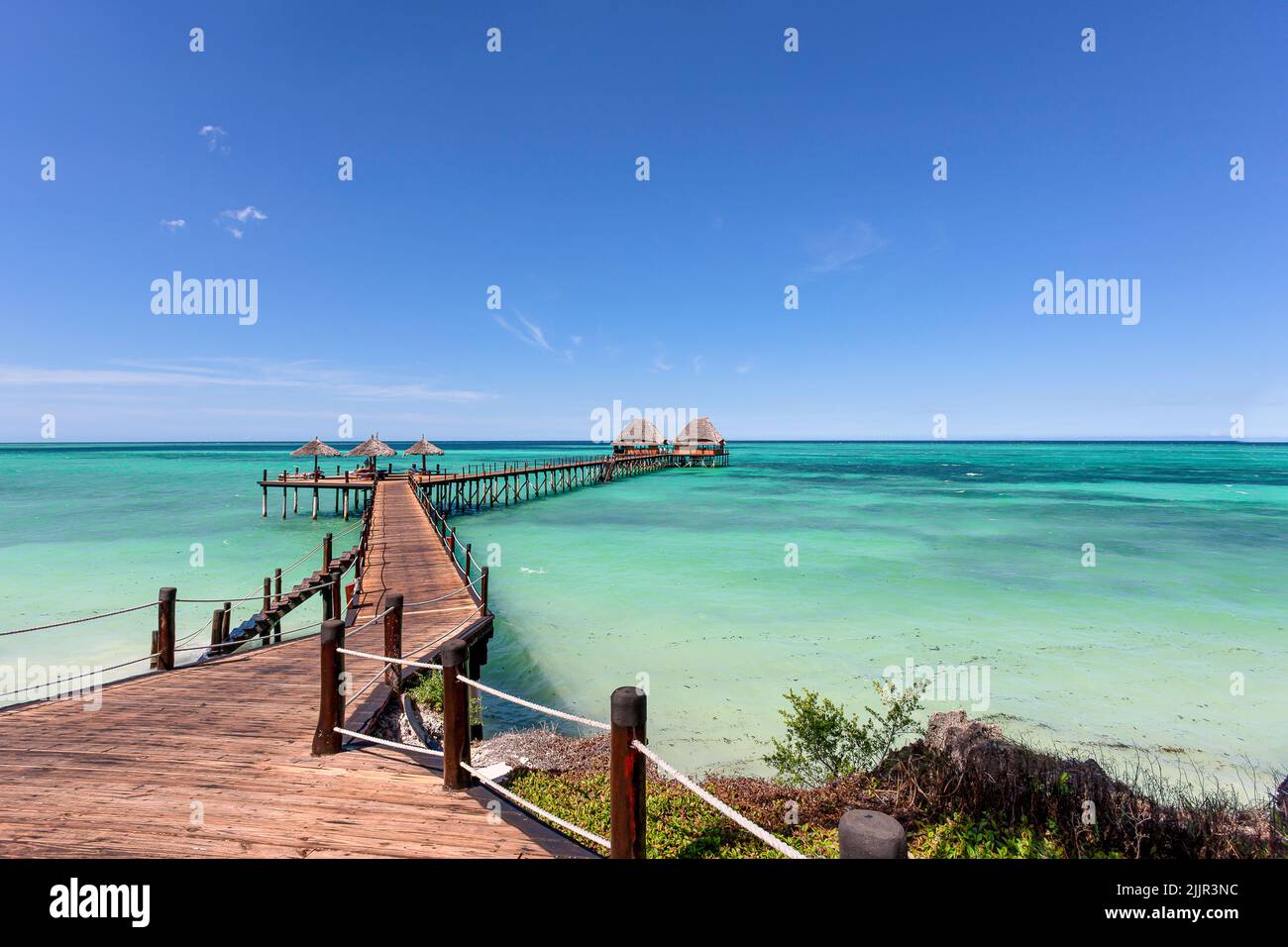 Wooden jetty with sunbathing terrace out into the ocean to a Tanzanian ...