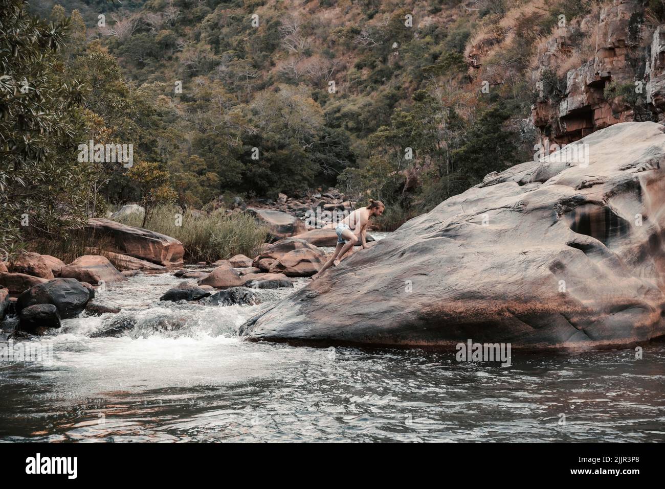 A beautiful shot of a female by the river in the mountains Stock Photo ...