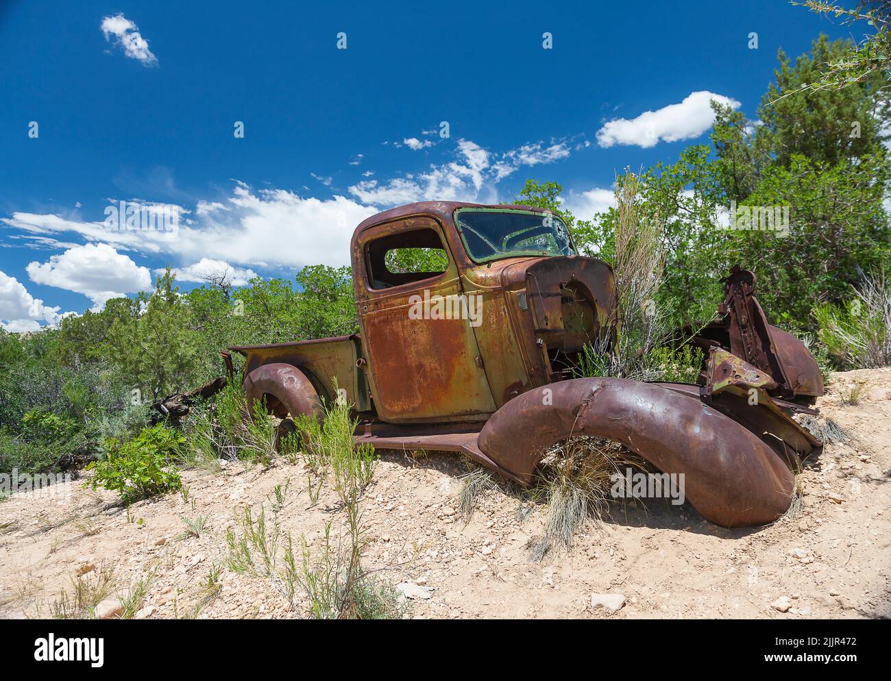Rusted and corroded old car grown into the landscape near Bryce Canyon ...