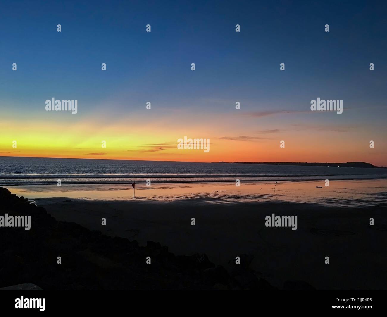 sunset on the sea, sunset and night at the same time, rocks and sand in ...