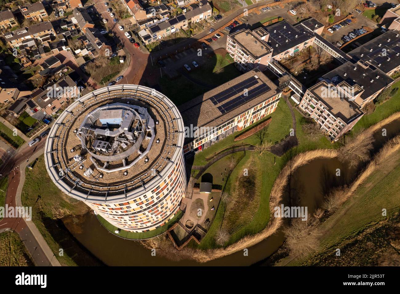 Aerial urban surrounding showing a round colourful tower and ...