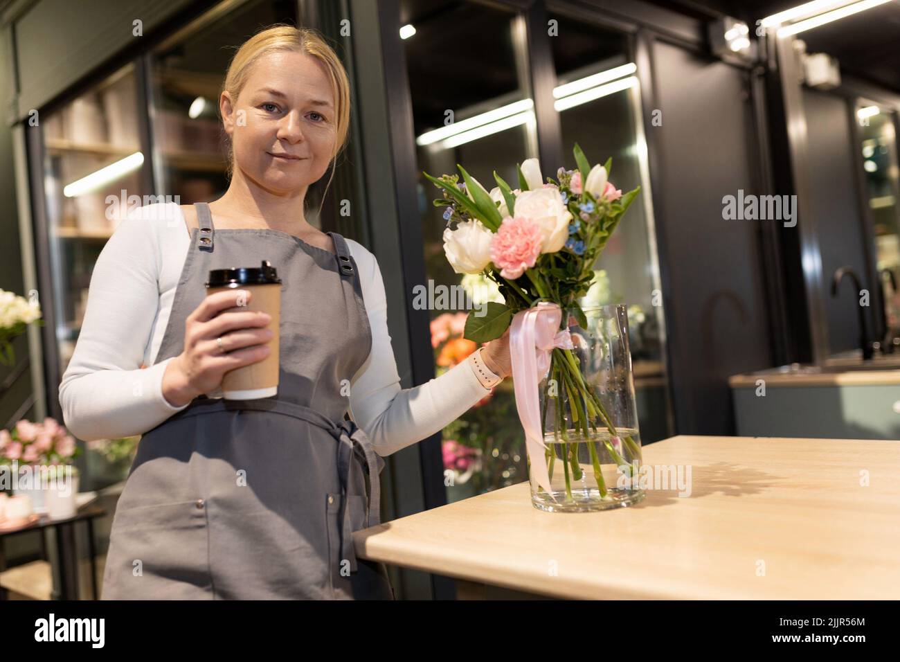 flower shop owner drinks coffee before work Stock Photo - Alamy