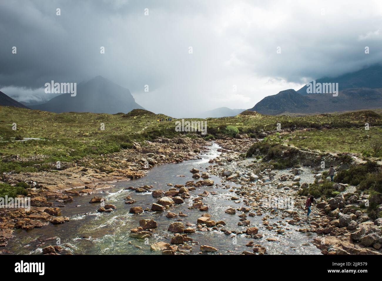 A shallow stream flowing in the Scottish highlands with mountains in ...