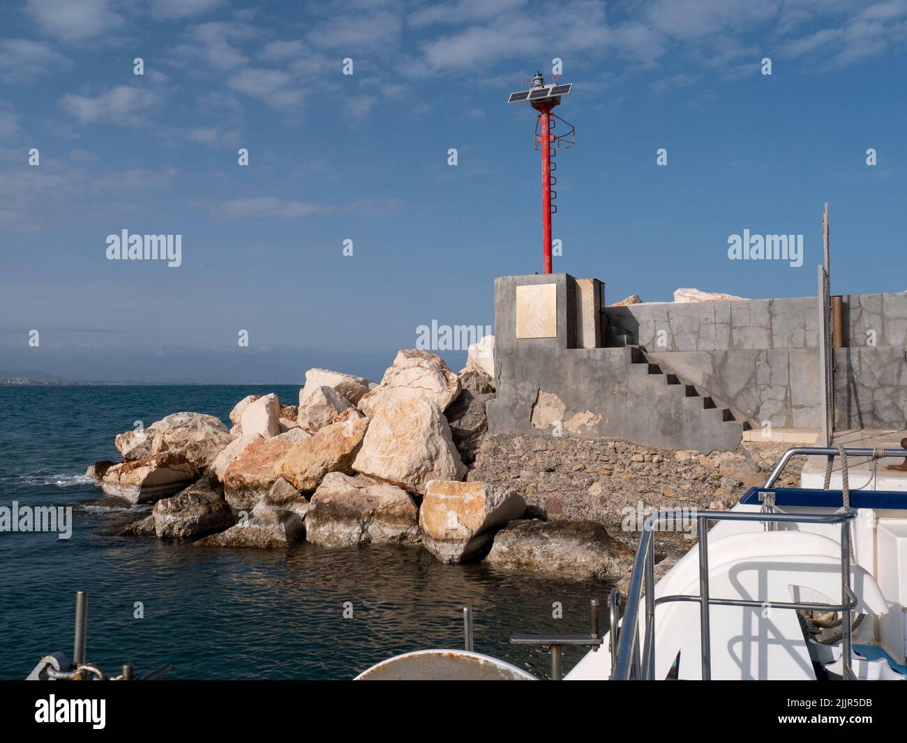 A solar panel tower and stones on the shore of Tabarca Island in Spain ...