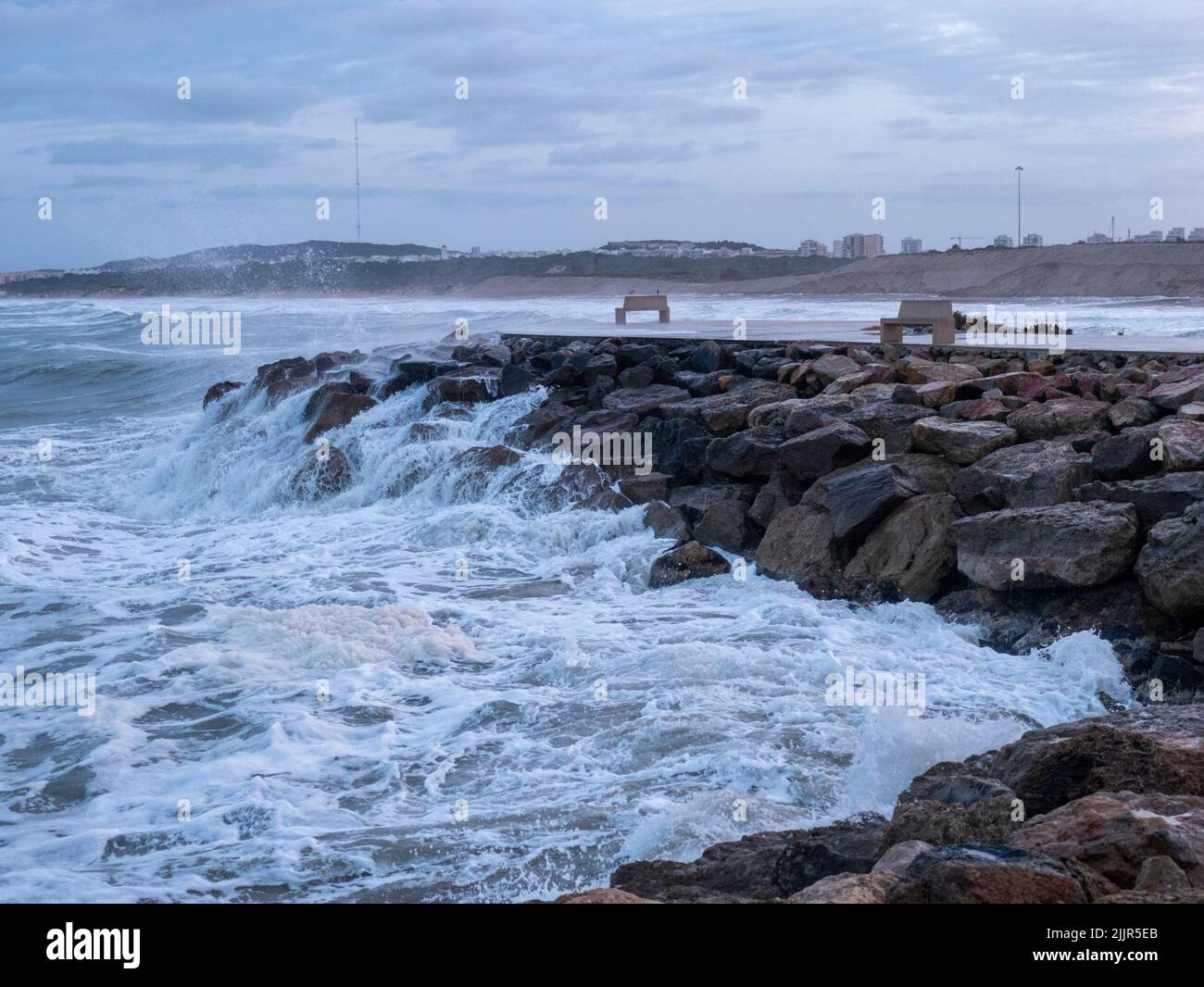 The waves crashing on the rocky shore of Guardamar del Segura, Spain ...