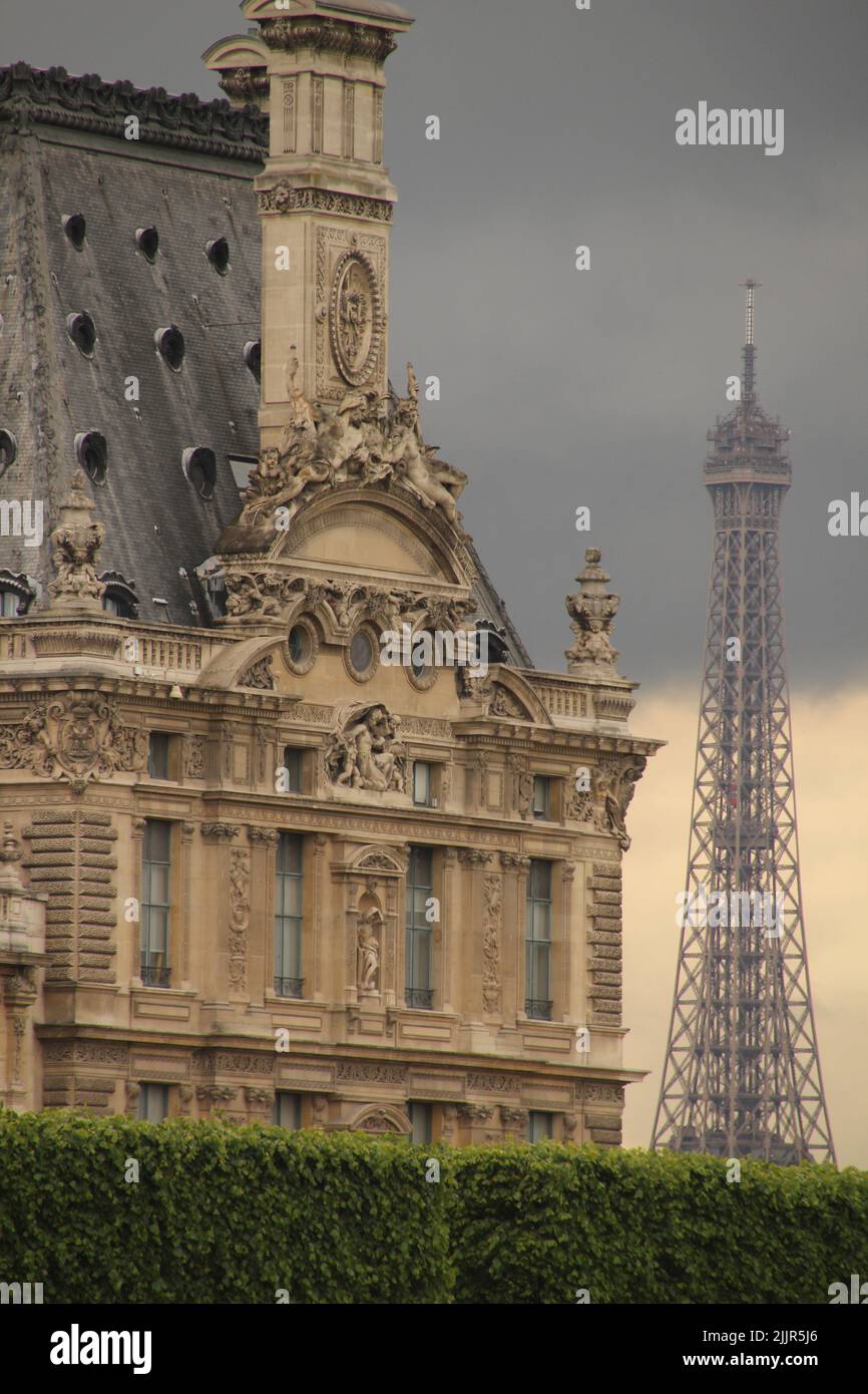 A vertical shot of architectural buildings with the Eiffel Tower in the ...