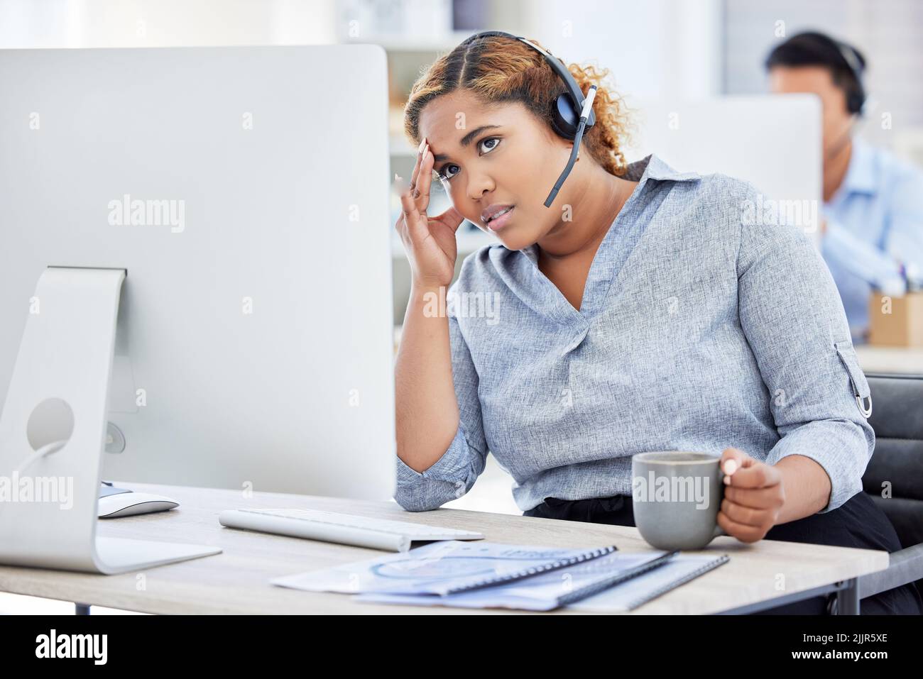 Tired, frustrated and stressed call center agent with a headache while ...