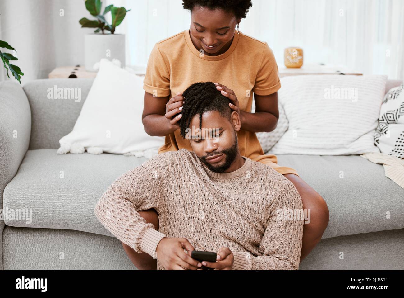 Our connection is all you need. a young couple using a phone at home ...