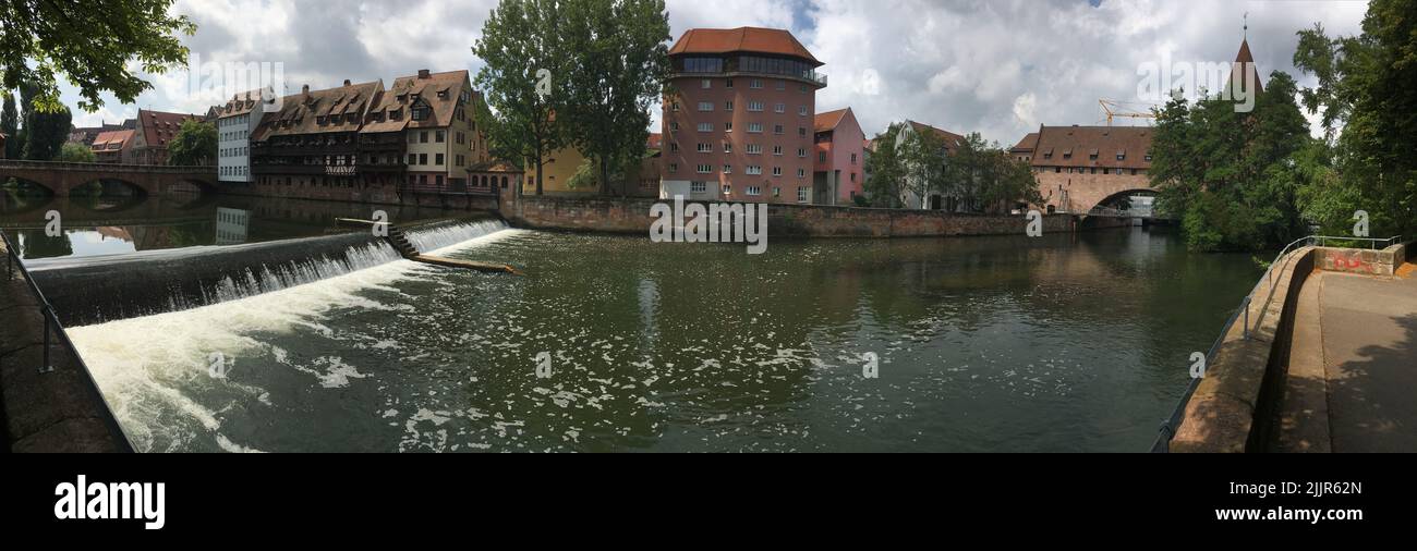A panoramic view of a river with a dam and a bridge in a town Stock ...