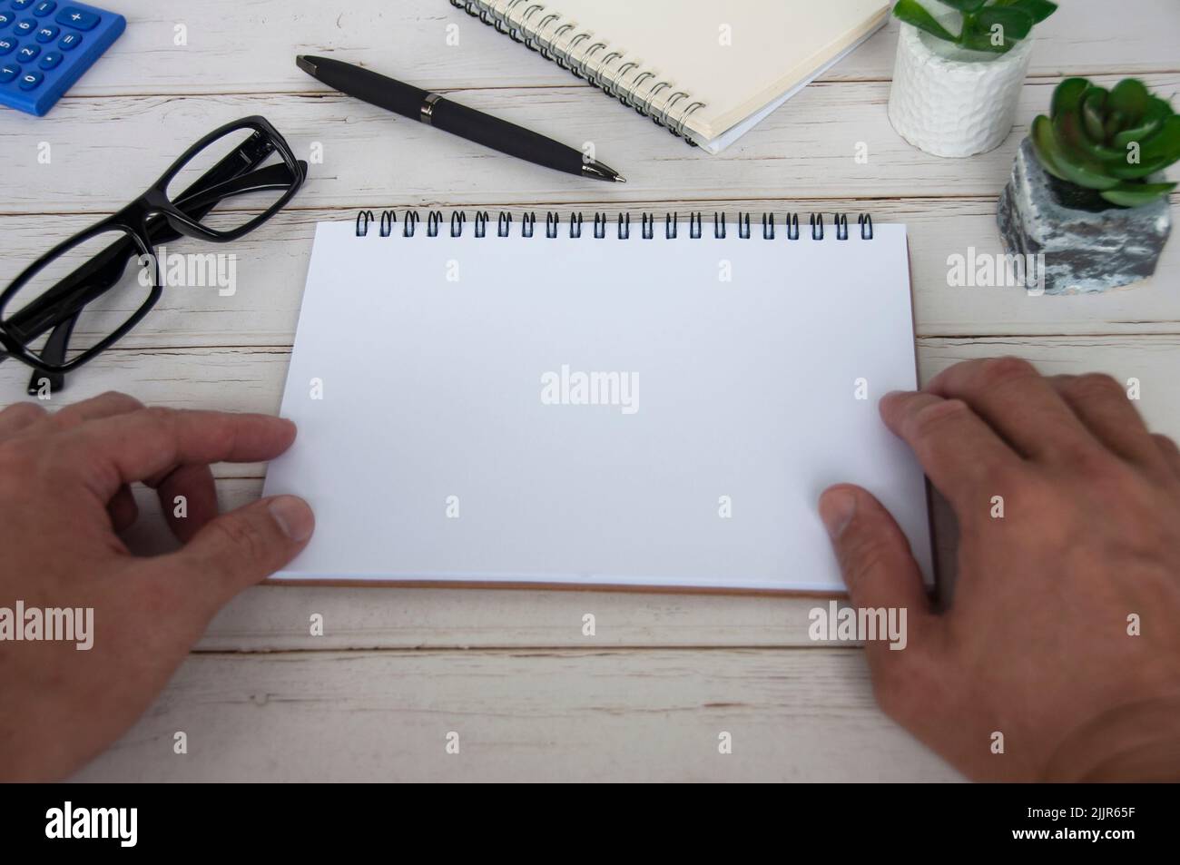 Hand holding blank white notepad with space customizable for text or ...