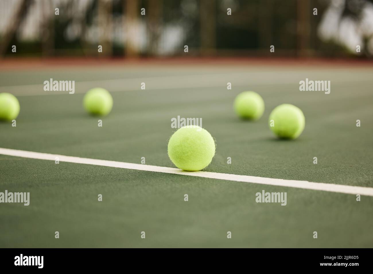 You need balls to play Tennis. tennis balls on an empty tennis court ...