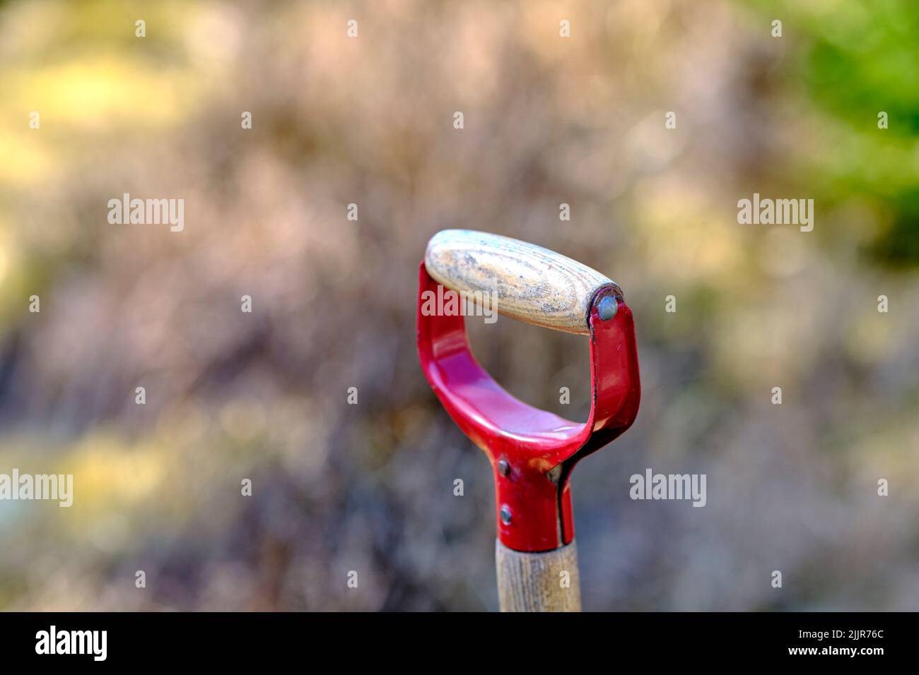 Closeup of wooden shovel in a garden or field with copy space. Zoom in ...