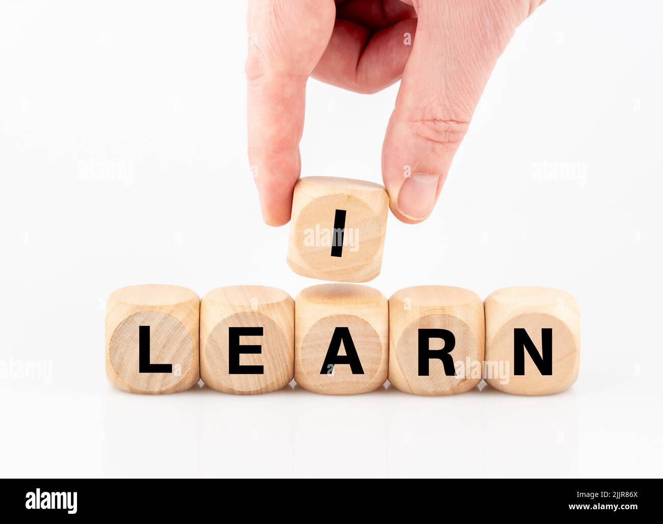 a hand lays the keyword I LEARN on a white background. Lifelong ...