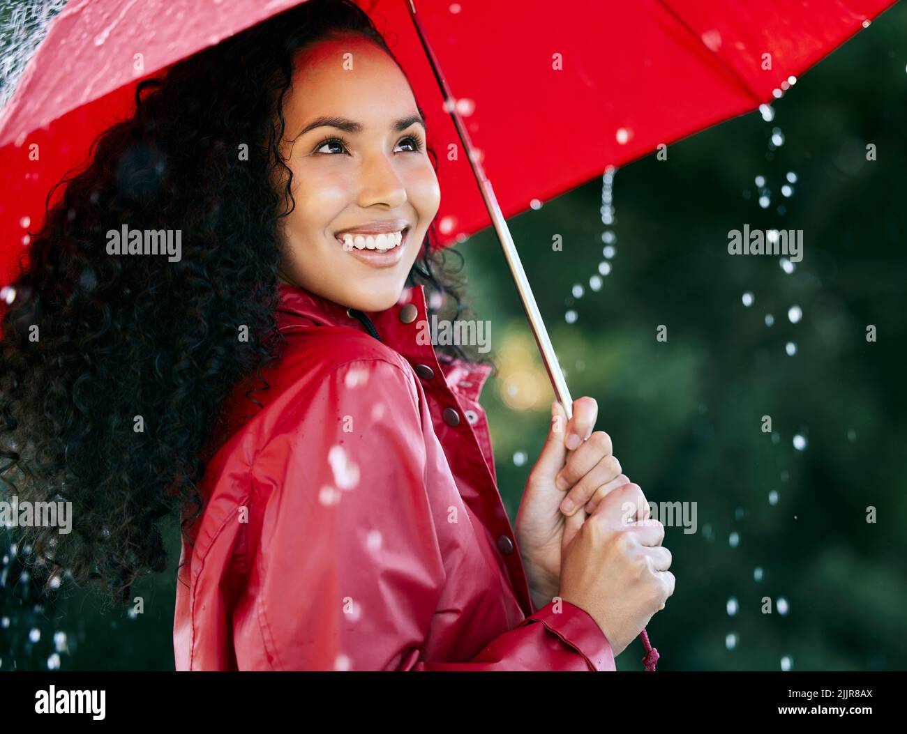 Its raining, its pouring. a beautiful young woman standing in the rain ...