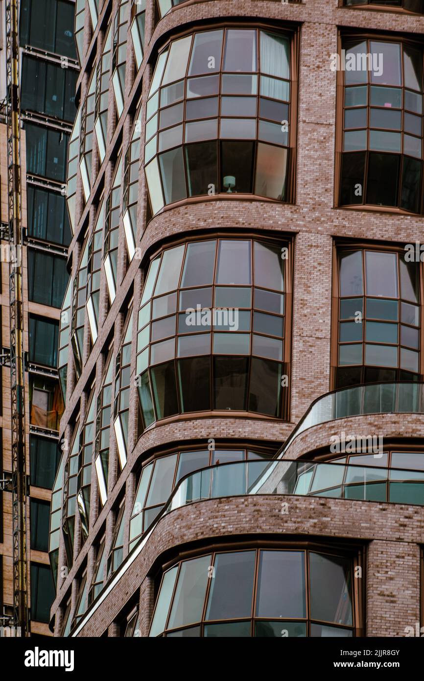 A vertical low angle of a modern building with wide windows Stock Photo ...