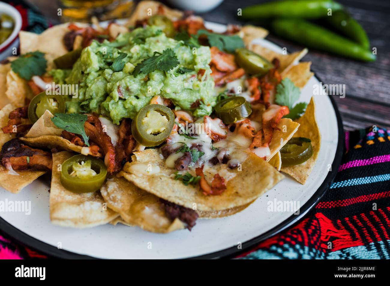 Mexican nachos chips with american cheese and avocado, traditional food ...