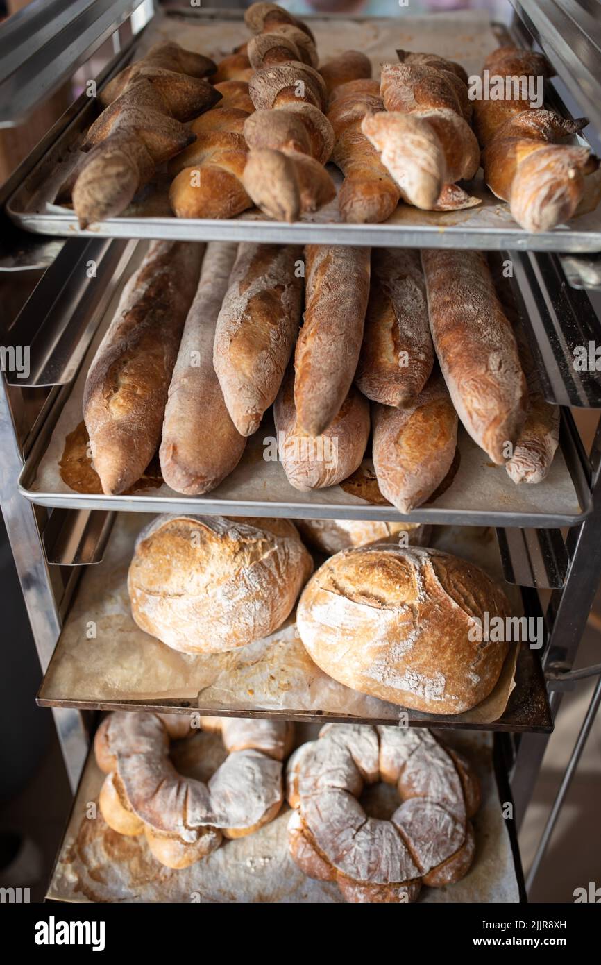 Finished French bread in the bakery on the racks. Baguettes, rustic ...