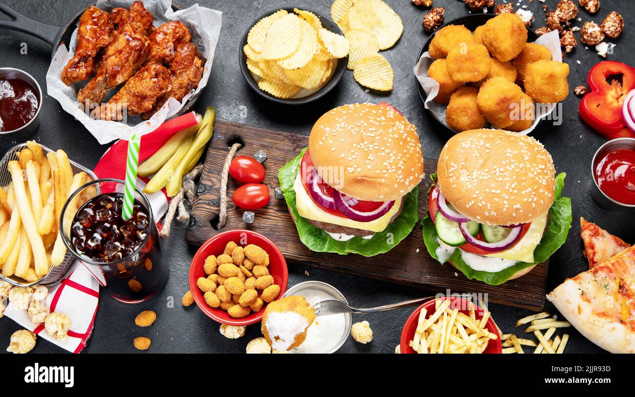 Fast food and unhealthy eating concept - close up of fast food snacks ...