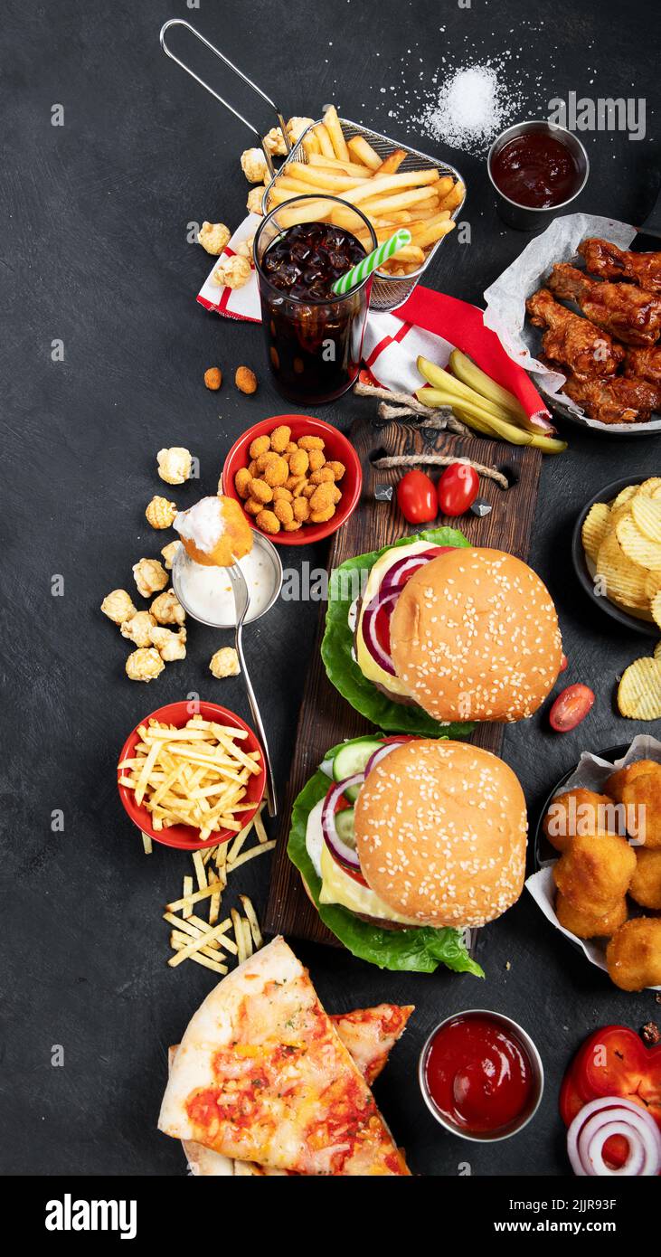 Fast food and unhealthy eating concept - close up of fast food snacks ...