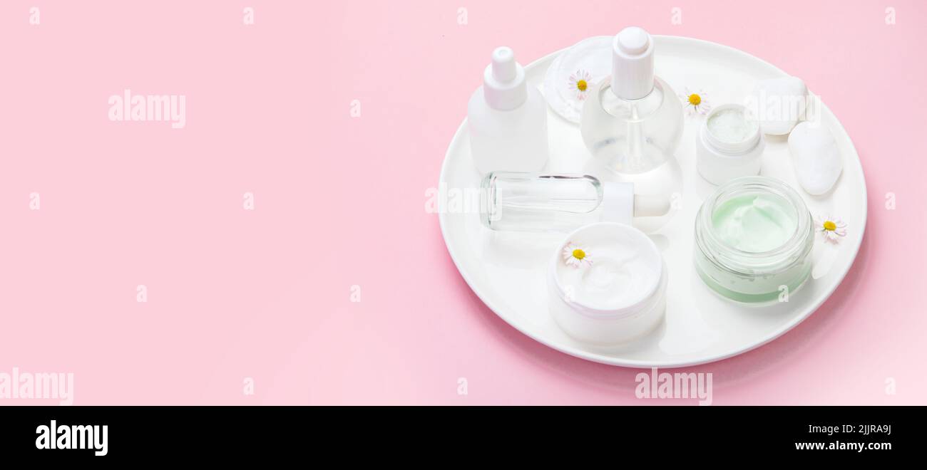 Face and body care products assortment on pink background. Natural ...