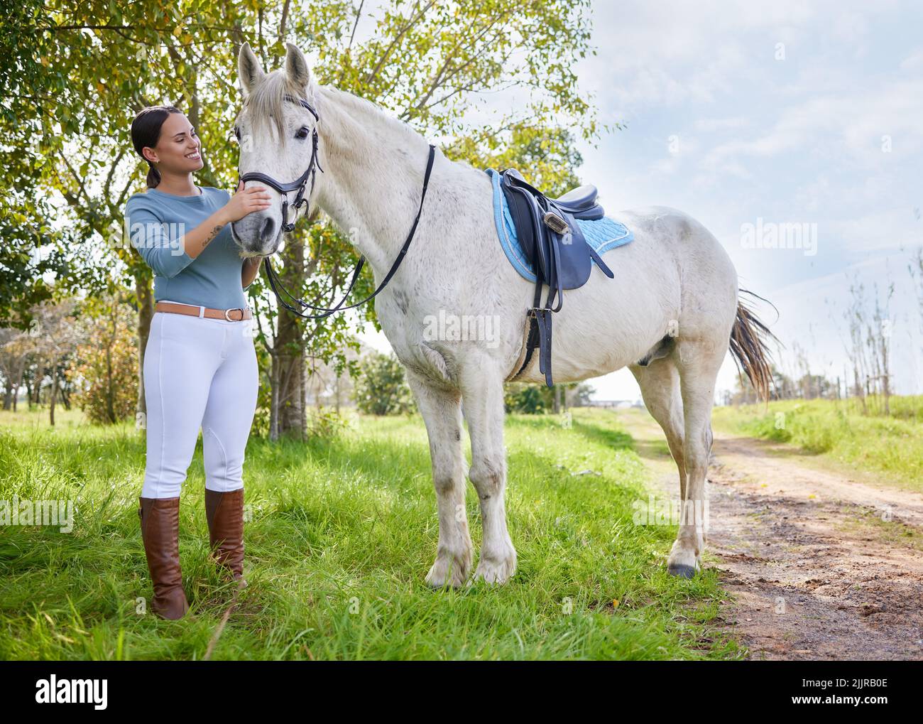 Looking back before riding out. an attractive young woman standing with ...