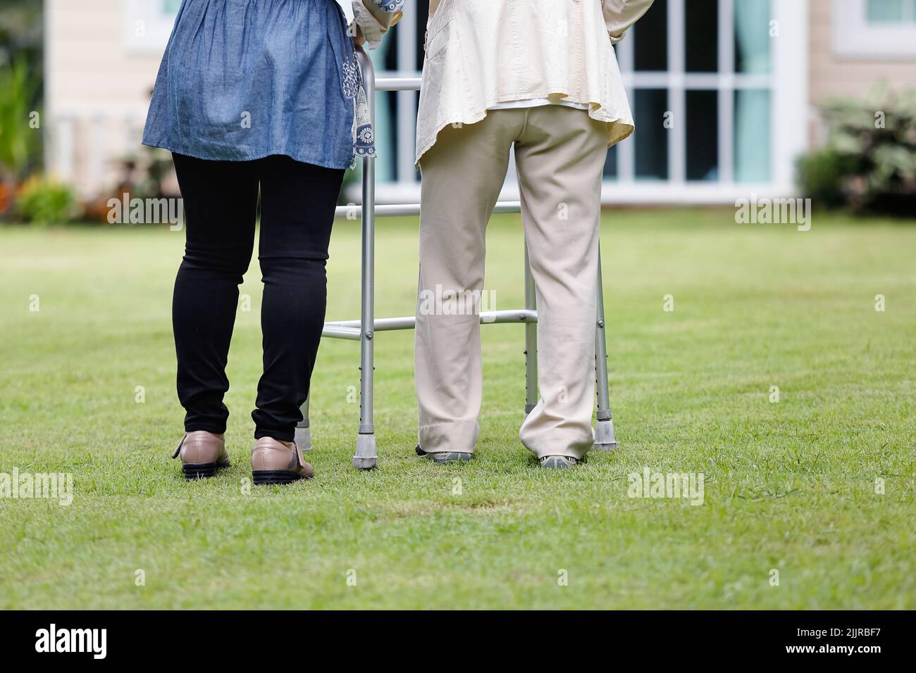 Elderly woman exercise walking in backyard with daughter Stock Photo ...