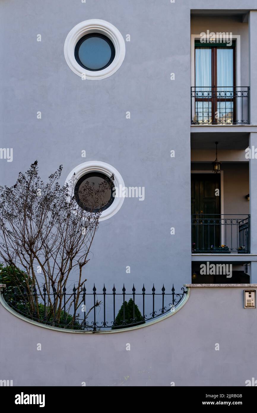 A vertical shot of a gray house with circle windows during the day ...