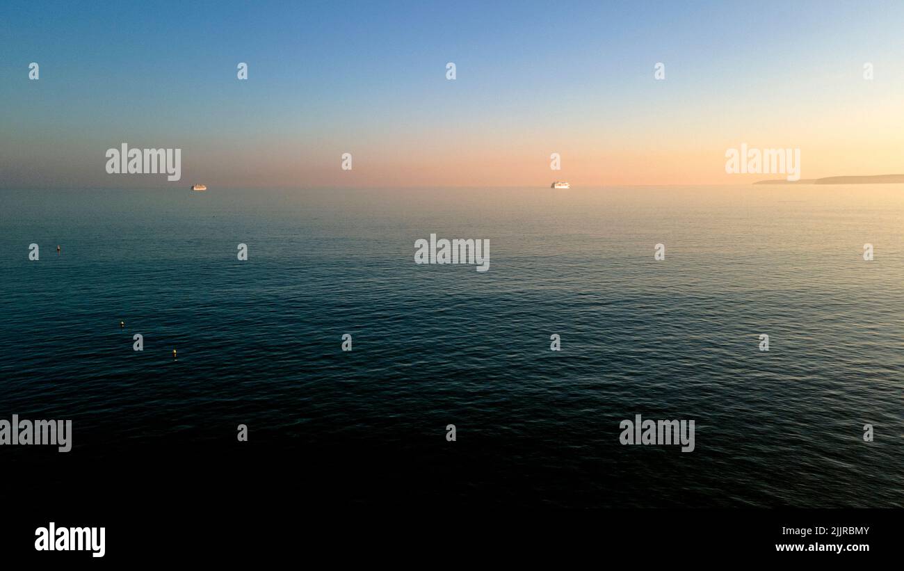 An aerial view of a serene ocean with two cruise ships seen in the far ...