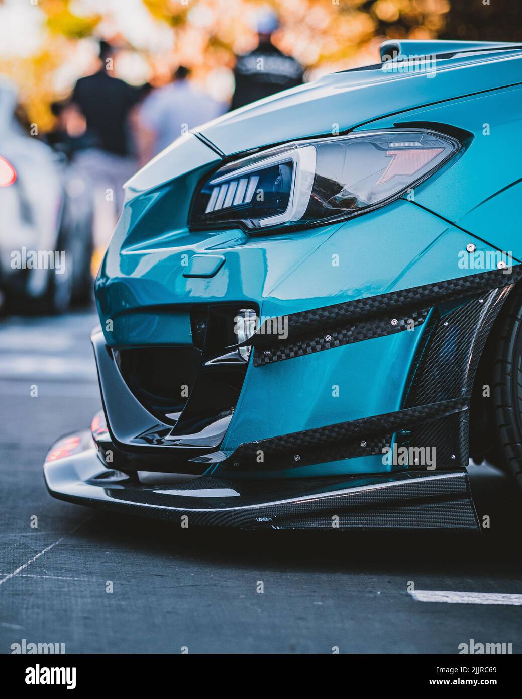 A side view of a blue sports car on the headlights and rim wheel on the ...